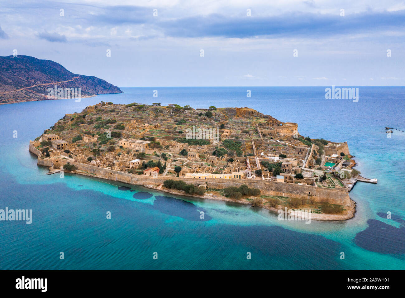 Aerial view of the island of Spinalonga with calm sea. Here were ...