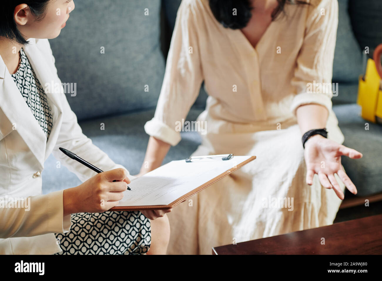 Cosmetologist asking female client questions about her lifestyle and ...