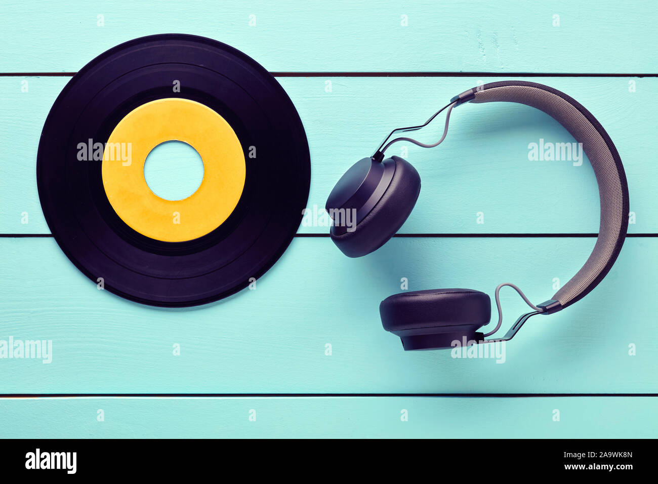 Vinyl record and a headphone on blue wooden table background. Listen ...