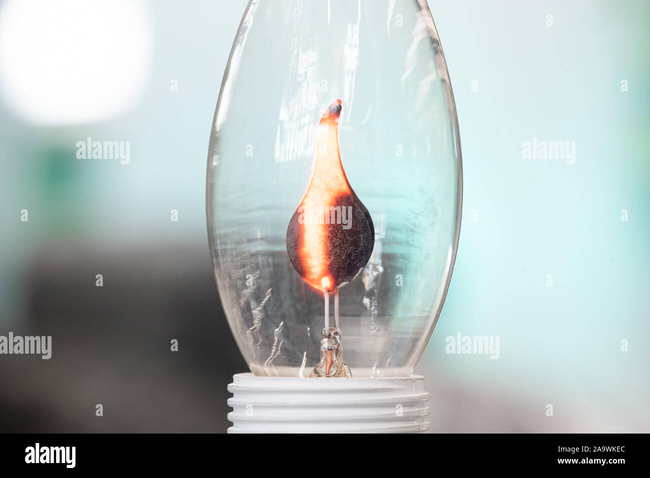 Burning lamp in a candle shape close up background Stock Photo - Alamy