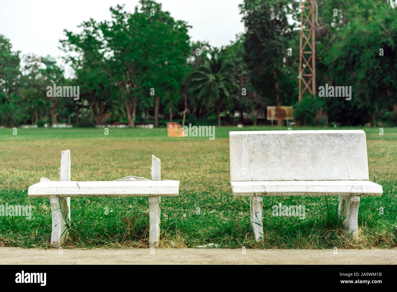 Old and broken long white cement bench for relaxing after the exercise ...