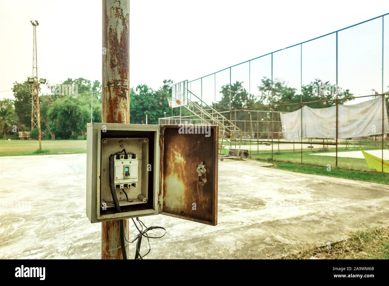 Old rusty electrical power control box on rusted electric pole in the ...