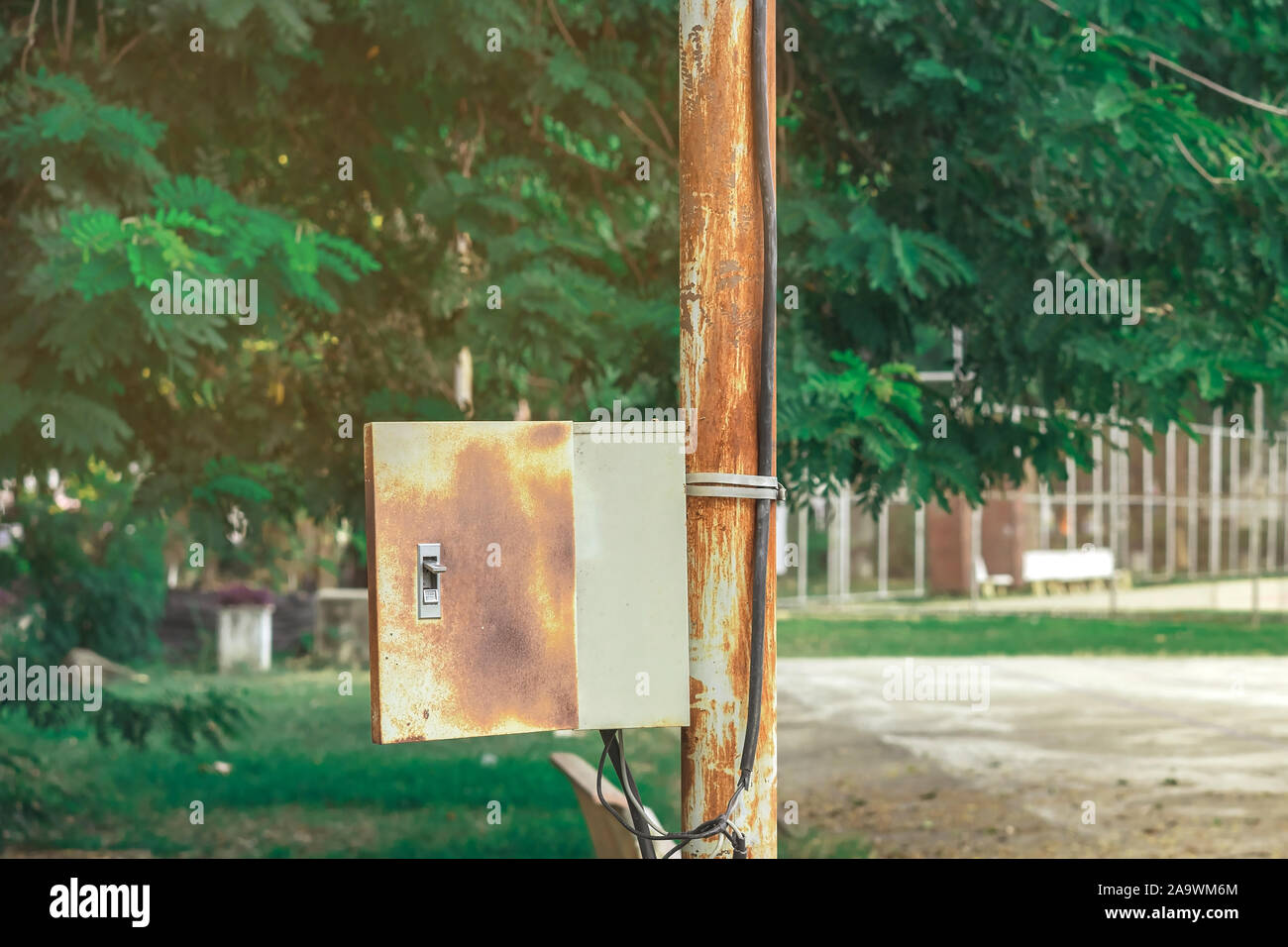 Old rusty electrical power control box on rusted electric pole in the ...