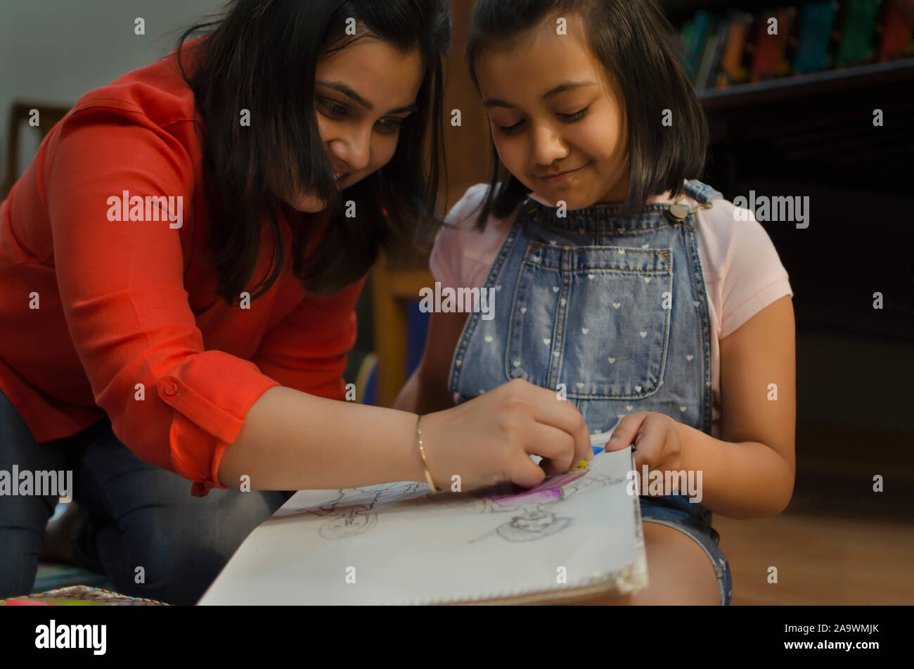 Mother helping her daughter in drawing Stock Photo - Alamy