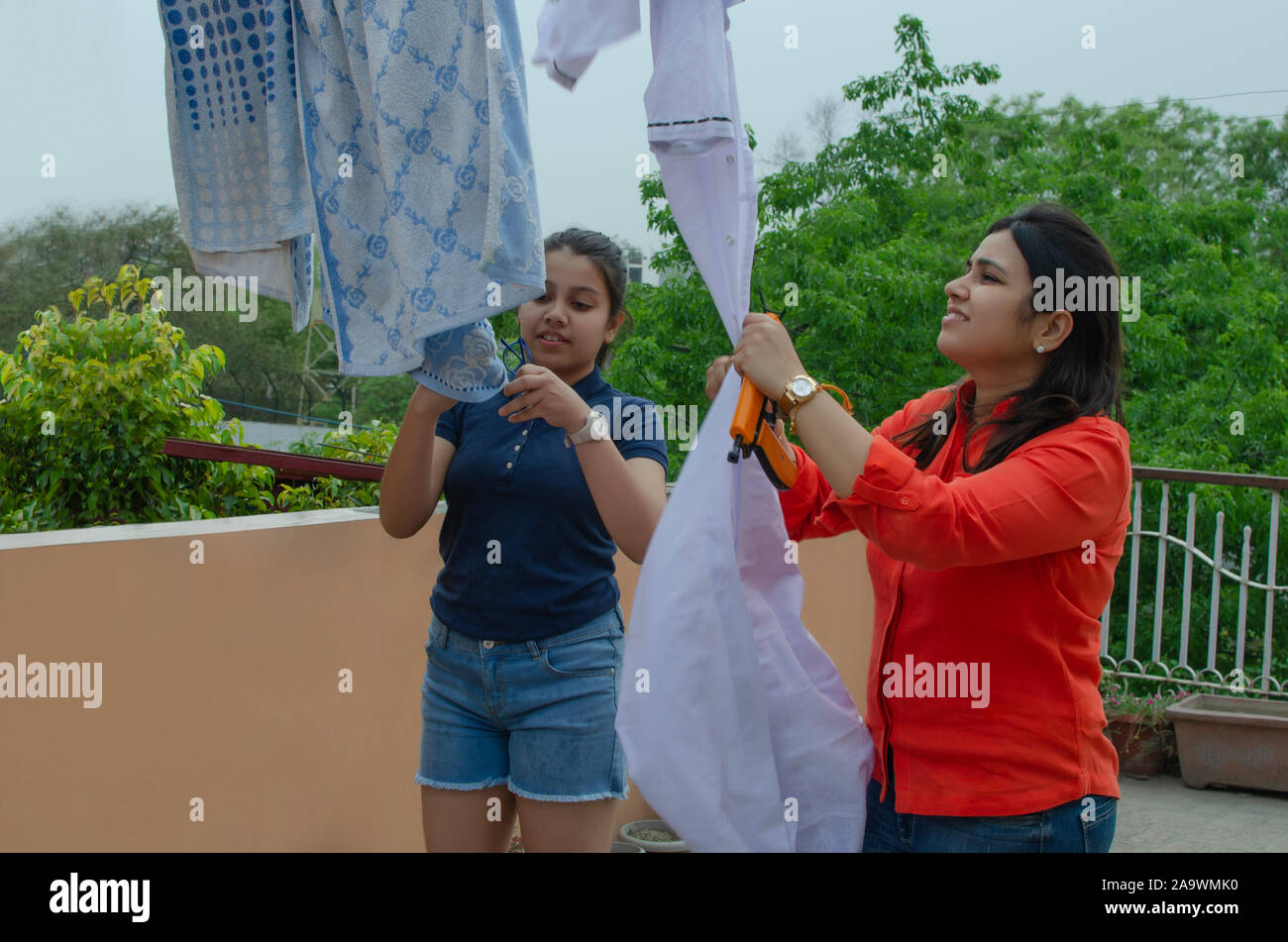 Young girl helping her mother Stock Photo - Alamy