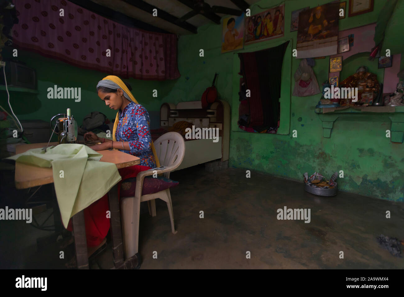 young girl stitching clothes in her hut Stock Photo - Alamy
