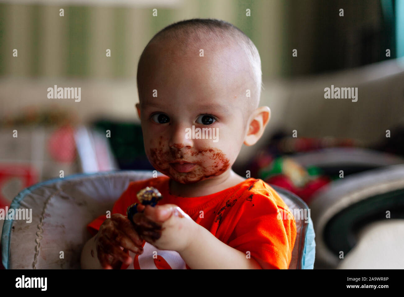 Little kid eating chocolate. Happy little boy smeared with chocolate ...