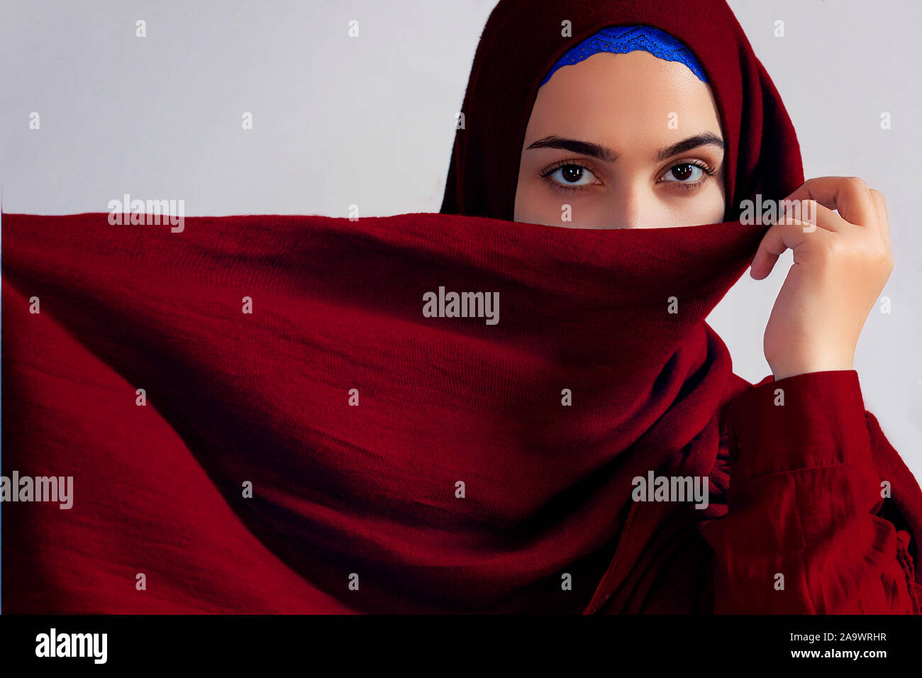 Beautiful muslim woman covers her face with a red cloth. Islamic ...