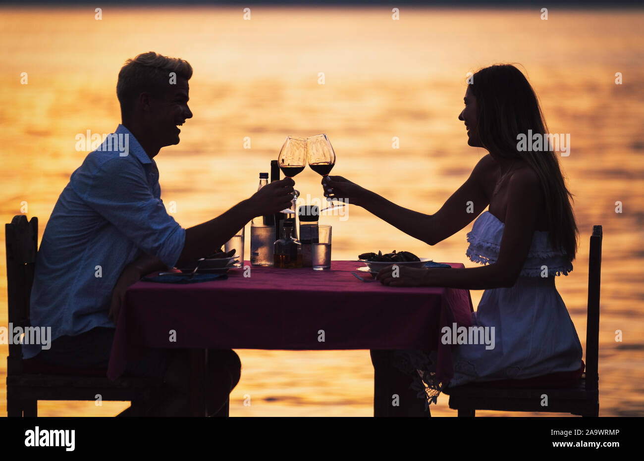 Young romantic couple toasting during dinner on tropical vacation Stock ...