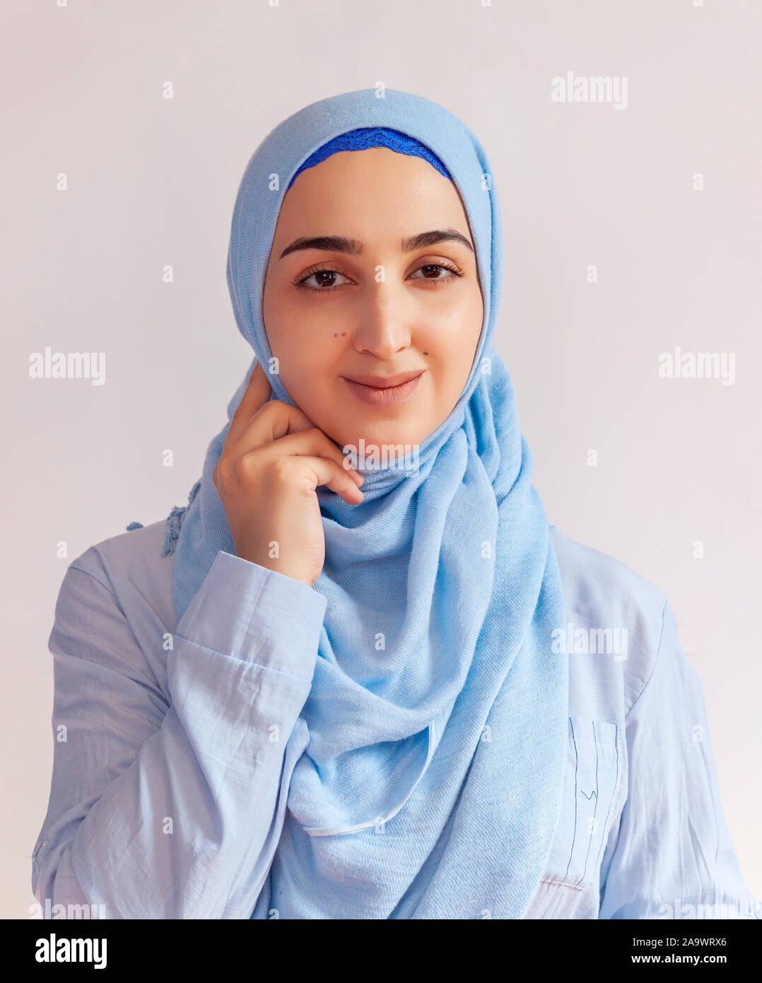 Beautiful Muslim woman in hijab against white background. Portrait of pretty middle-eastern ...