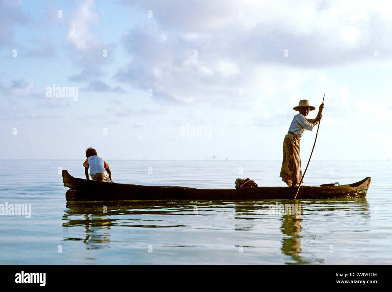 Indonesia. Sulawesi. Sama-Bajau people. Old woman standing paddling in ...