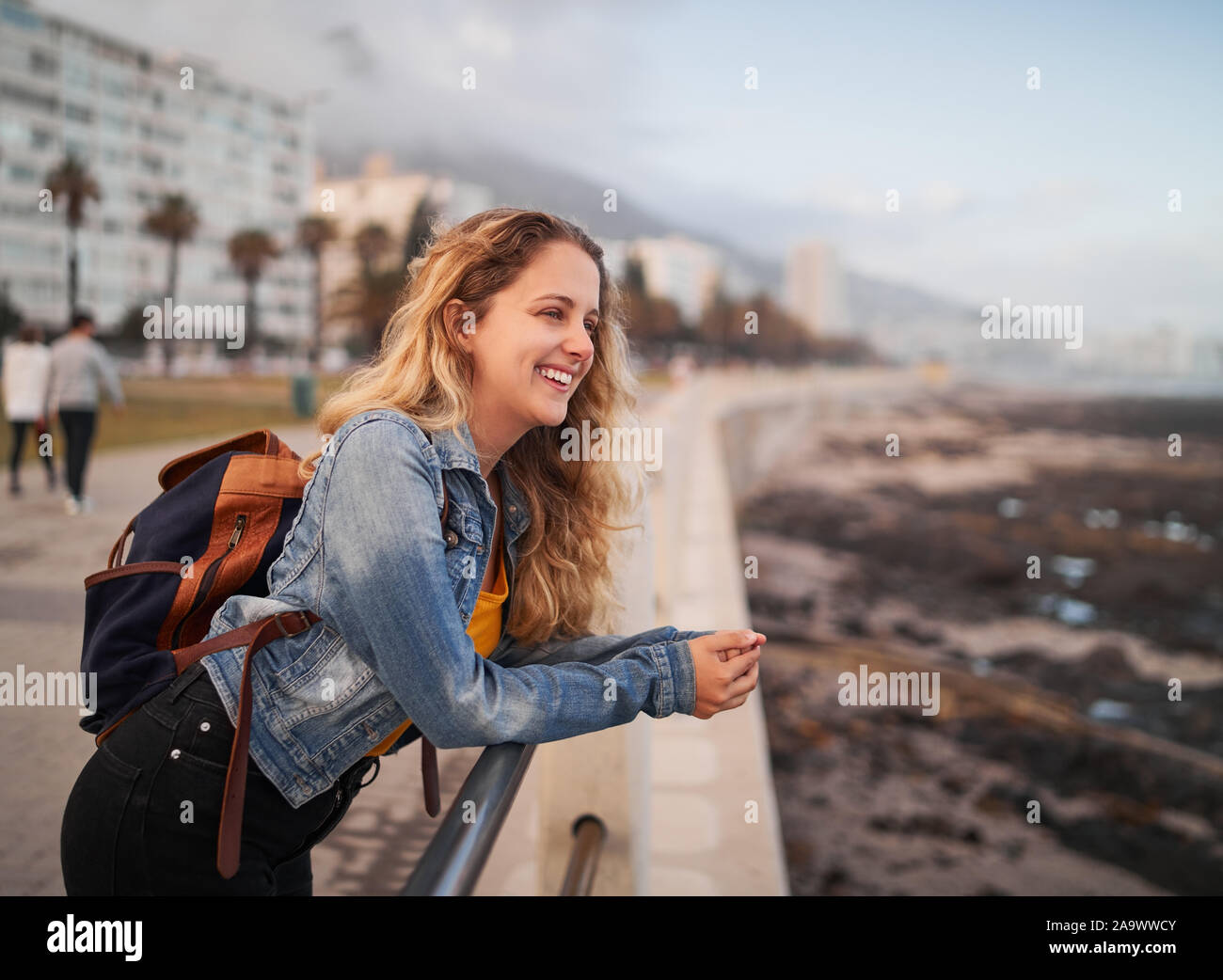 Side view of a smiling female traveler with her backpack on his back ...
