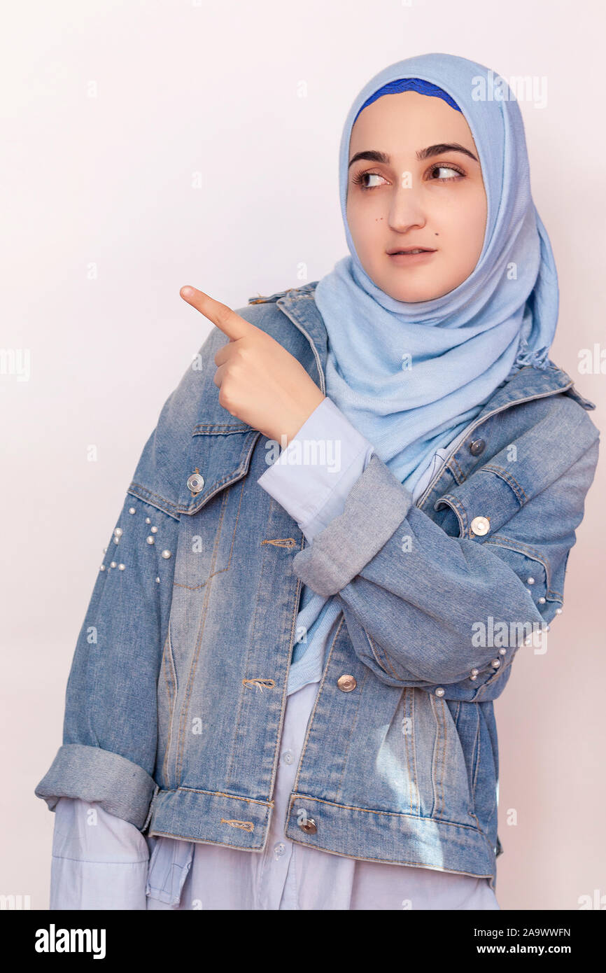Cute Muslim woman with cheerful face expression points away with her ...