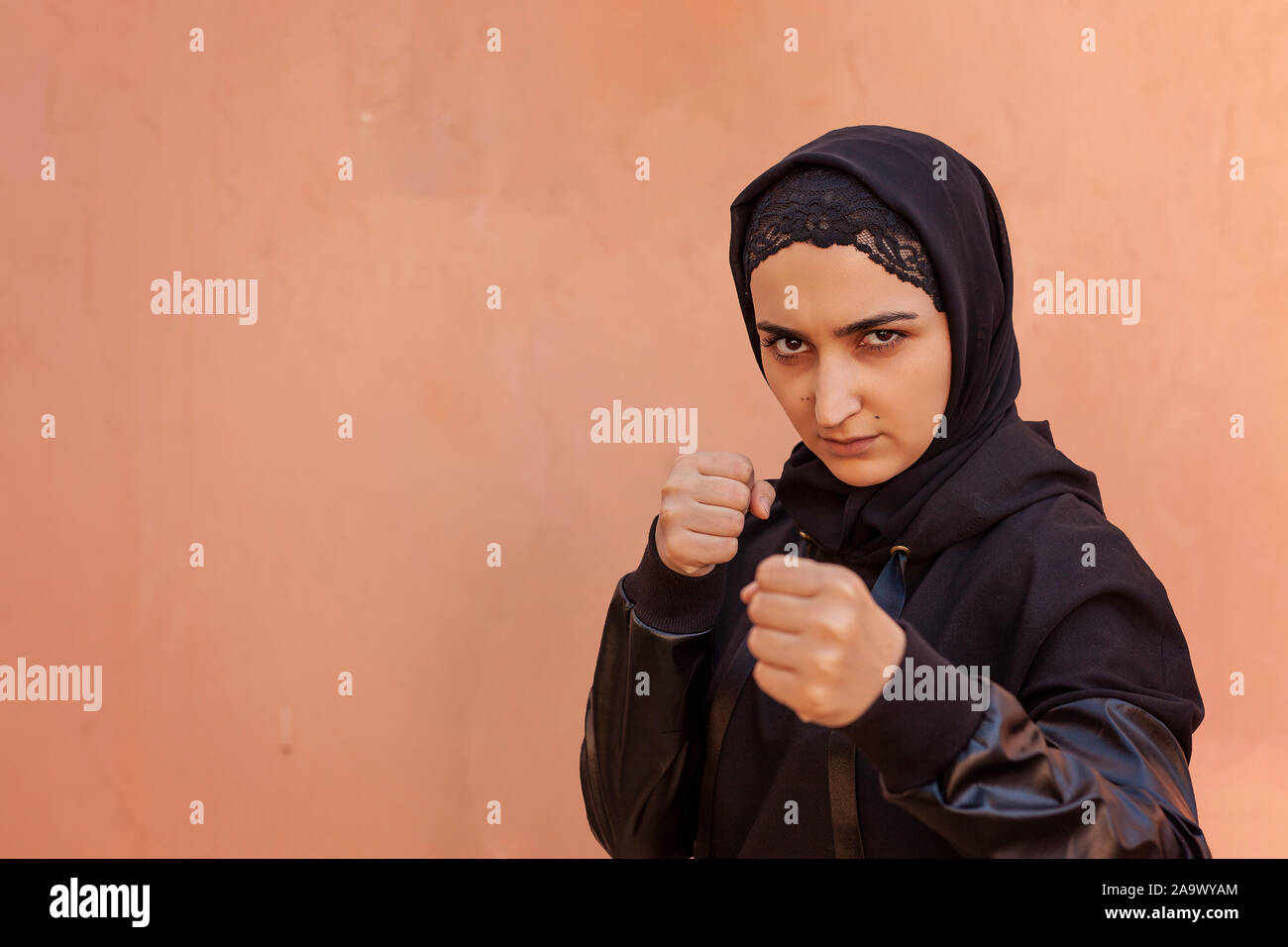 A Muslim boxer woman in Islamic sportswear. Muslim fighter boxer posing ...