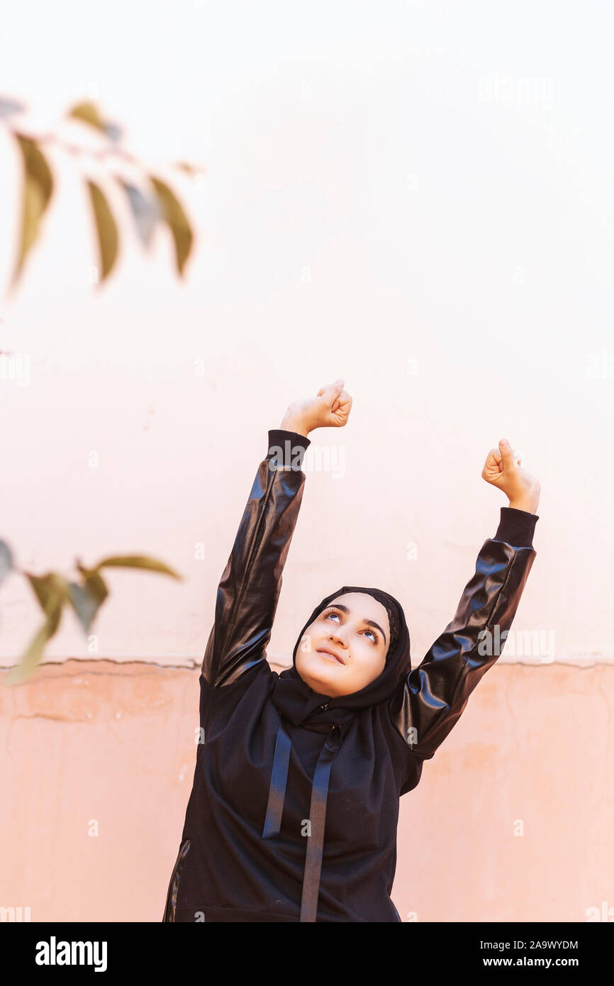 Muslim woman does physical exercises. Middle-eastern woman in hijab ...