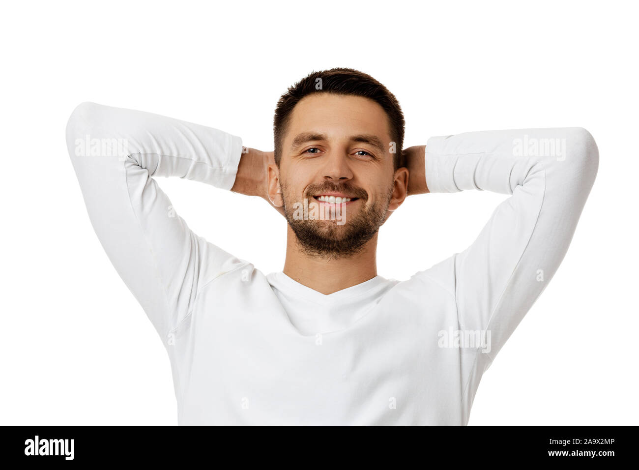portrait of smiling handsome bearded man with arms behind the head in ...