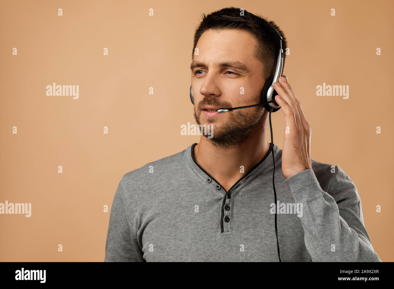 handsome call center worker man isolated on beige background. Young ... handsome call center worker man isolated on beige background. Young ...