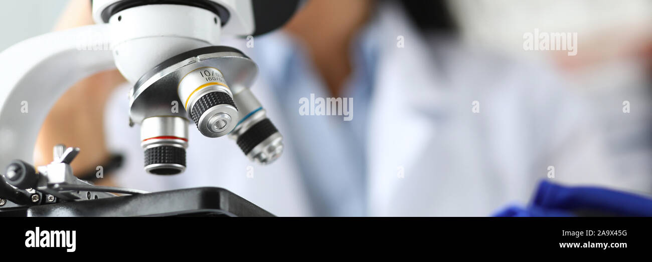 Scientific microscope lens with female analyst in background Stock ...