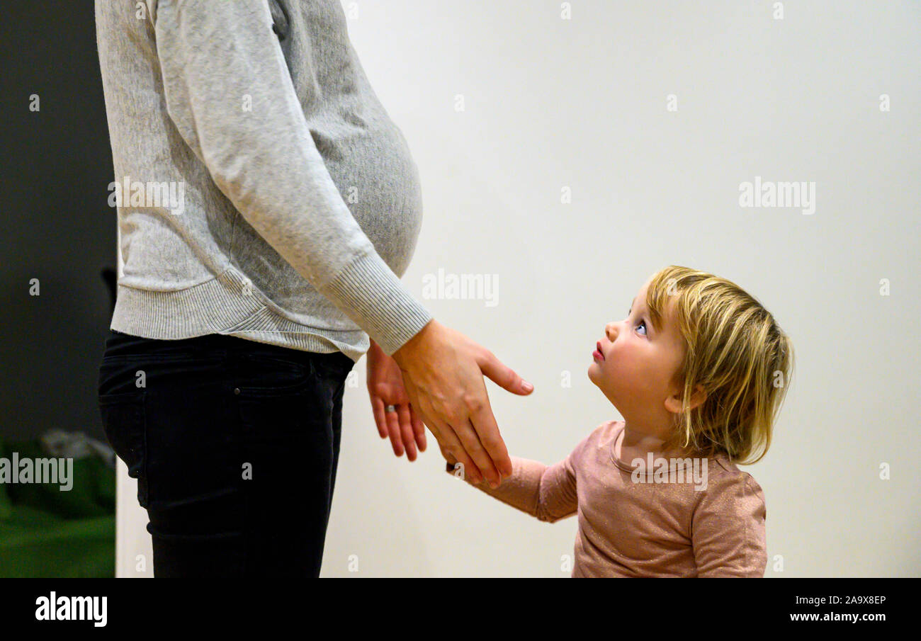 Pregnant mother with two year old daughter and baby bump Photograph ...