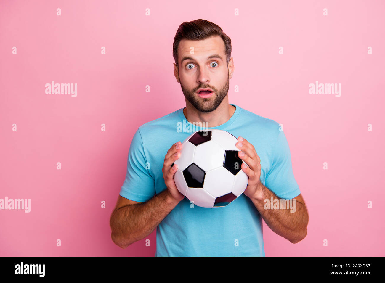 Photo of amazed surprised man in stupor holding soccer ball with hands ...