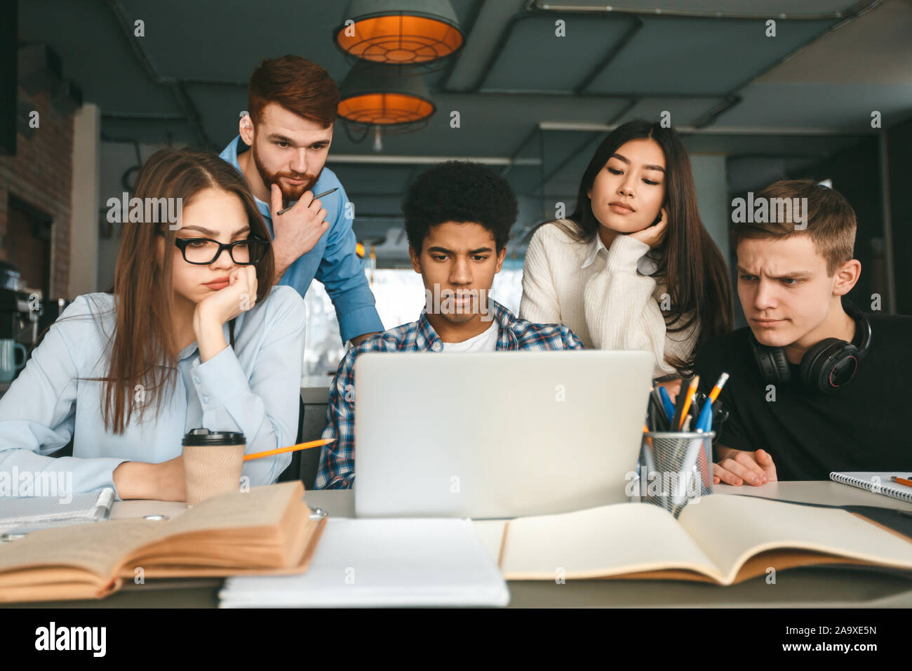 Smart serious students working on project in front of laptop Stock ...