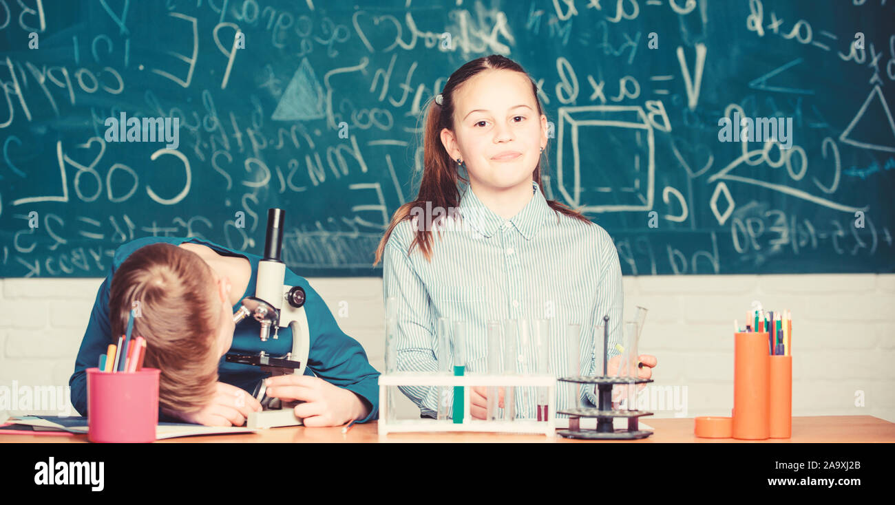 Girl and boy communicate while conduct school experiment. Children ...