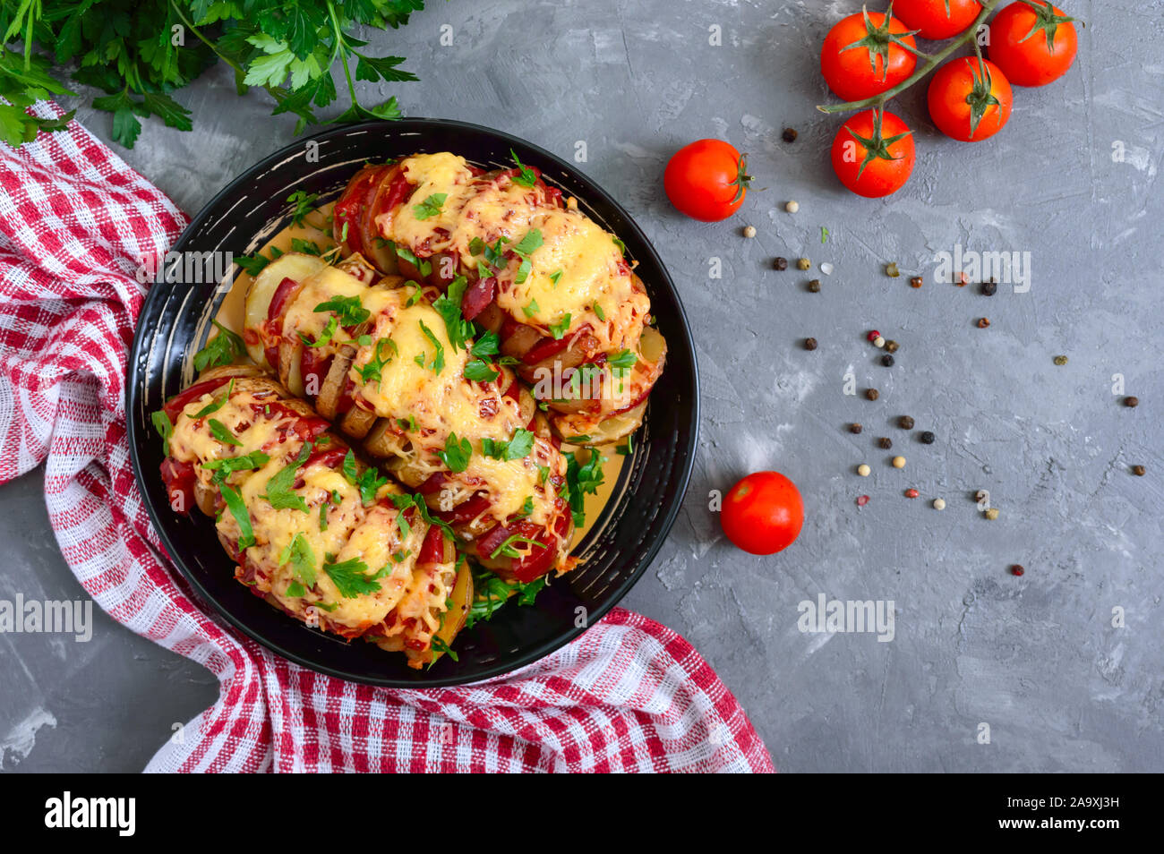 Hasselback potato stuffed with salami, cheese, ketchup, garlic and ...