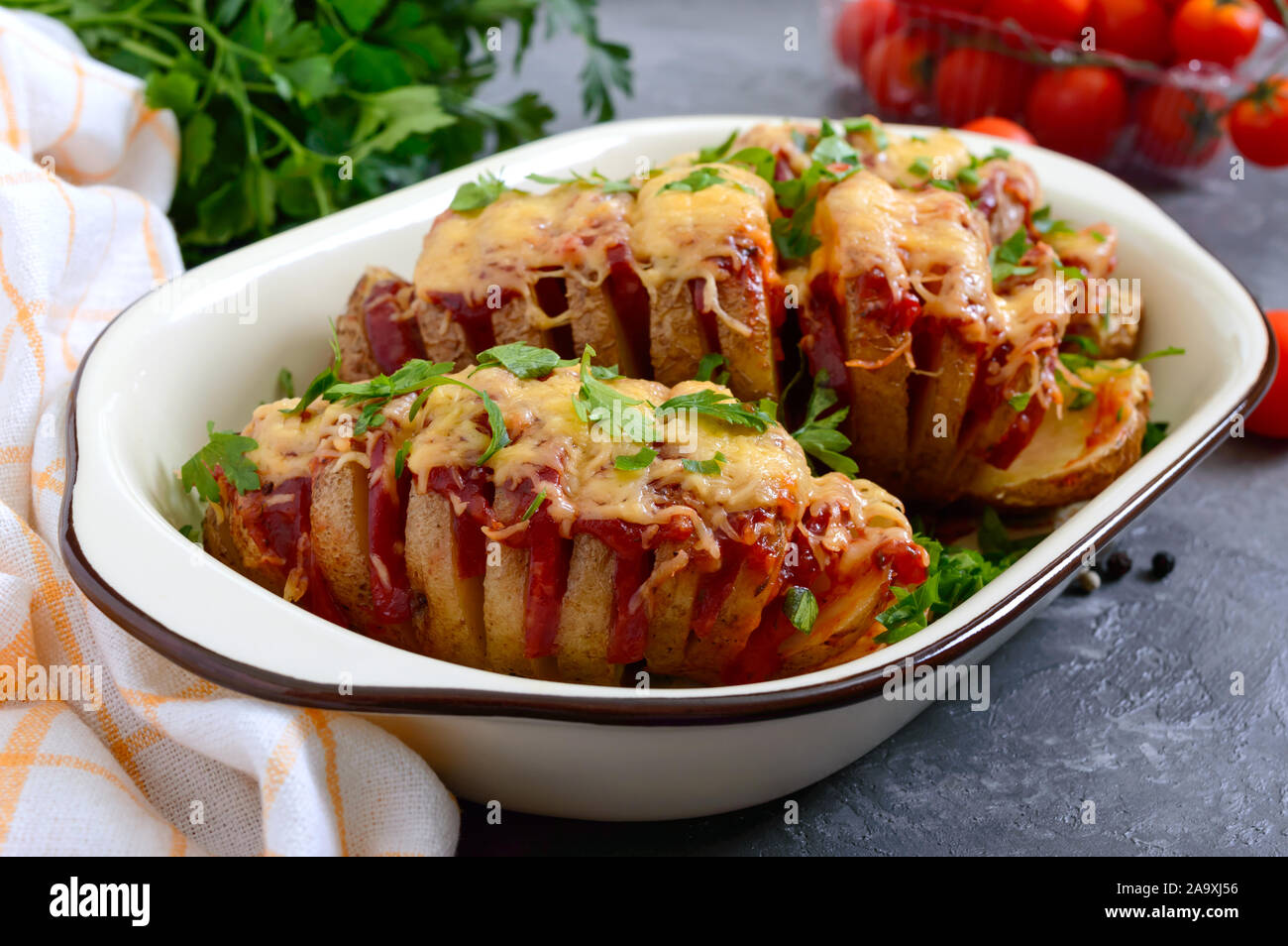 Hasselback potato stuffed with salami, cheese, ketchup, garlic and ...