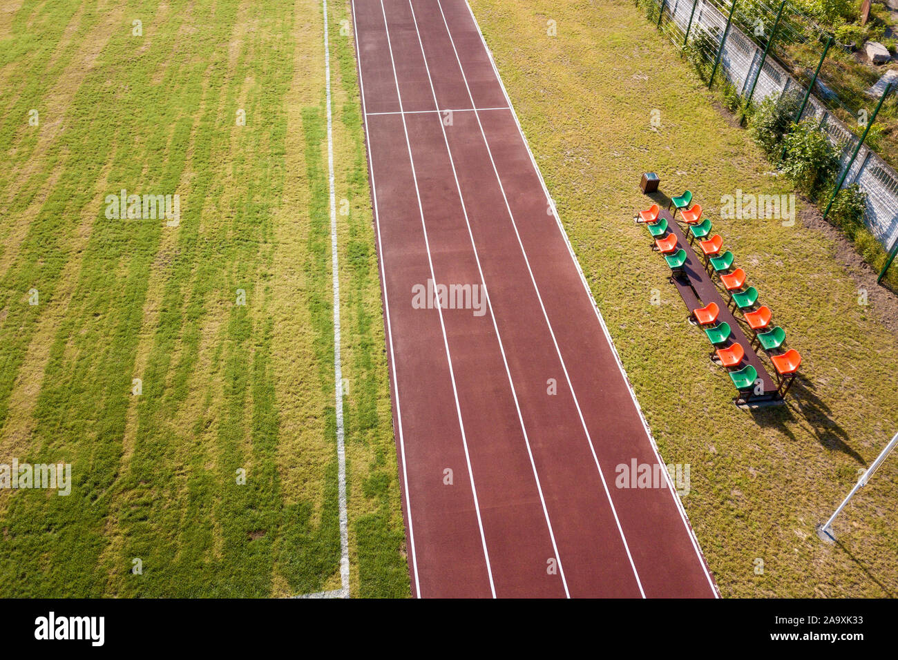 Top view of red running tracks and green grass lawn. Infrastructure for ...