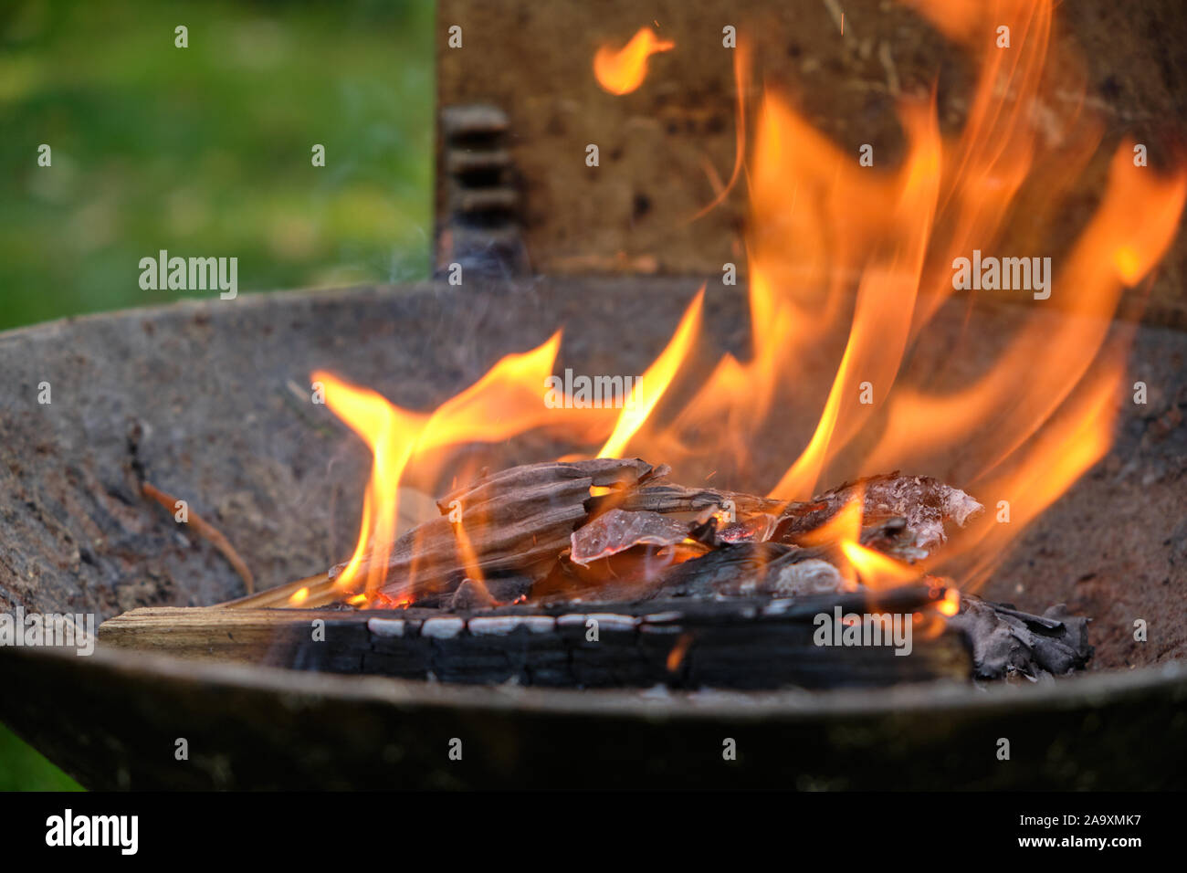 Flames coming out of a heap of cardboard, paper, wood and twigs before ...