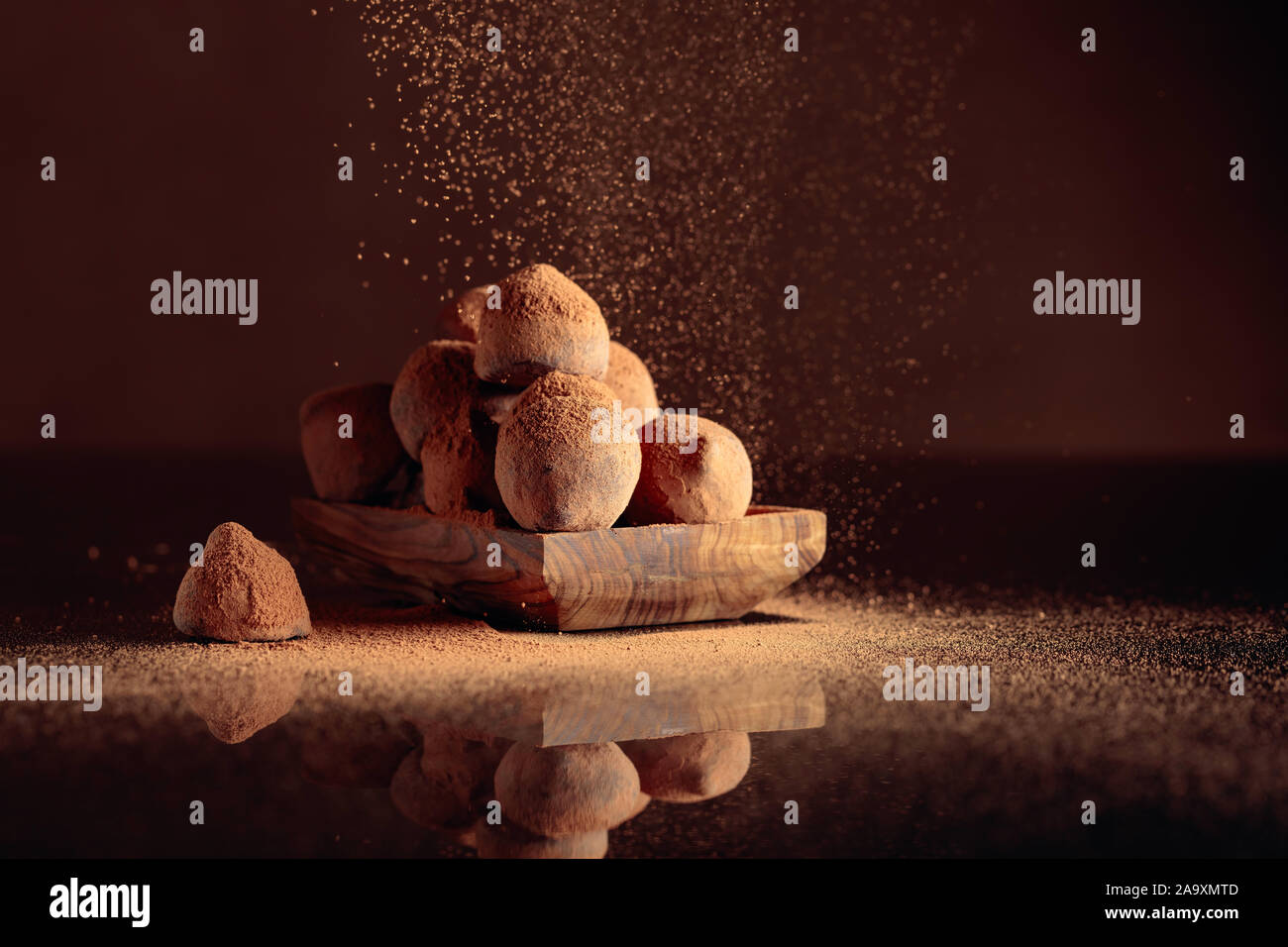 Chocolate truffles in small wooden dish sprinkled with cocoa powder ...