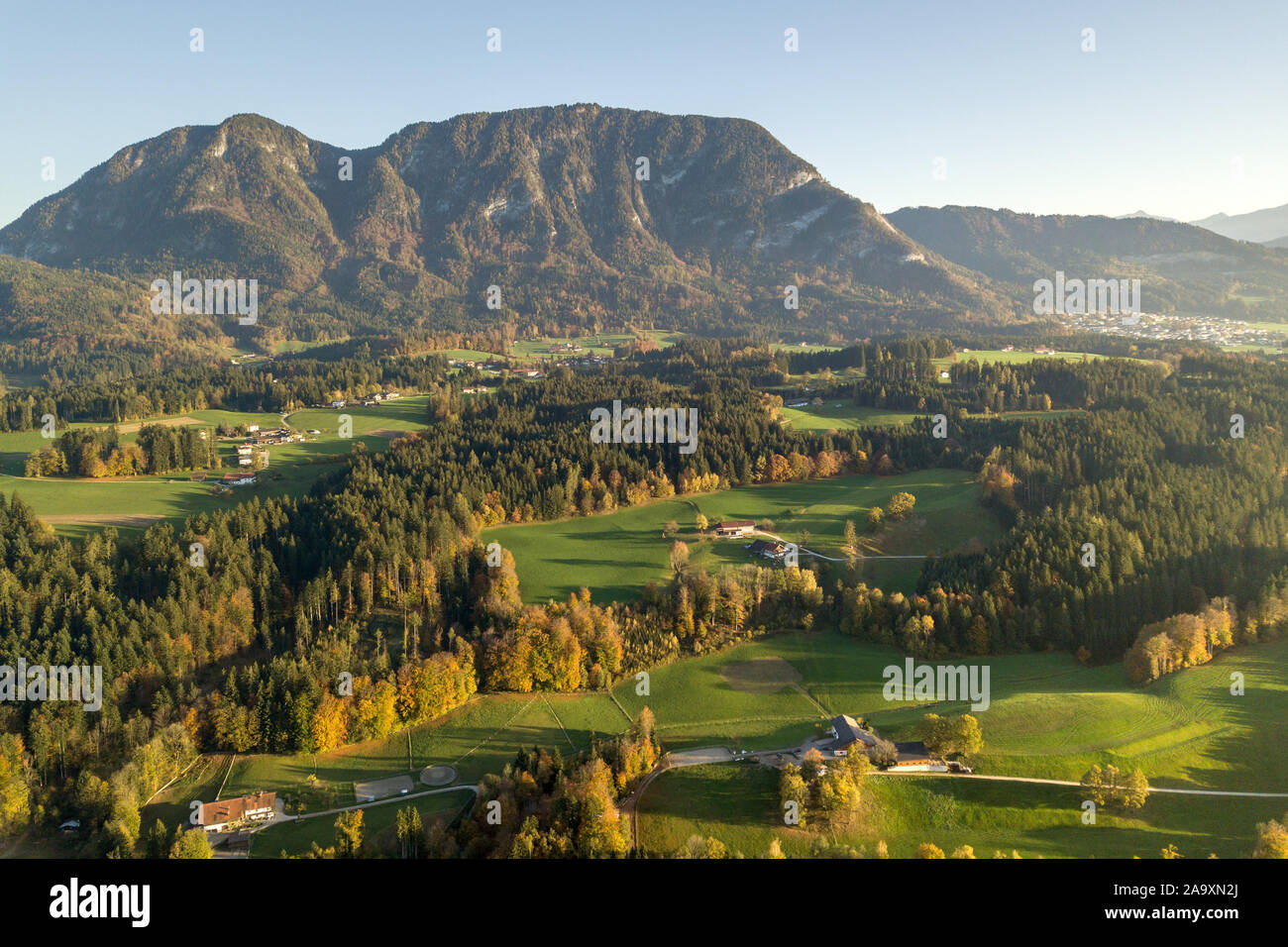 Aerial view of green meadows with villages and forest in austrian Alps ...