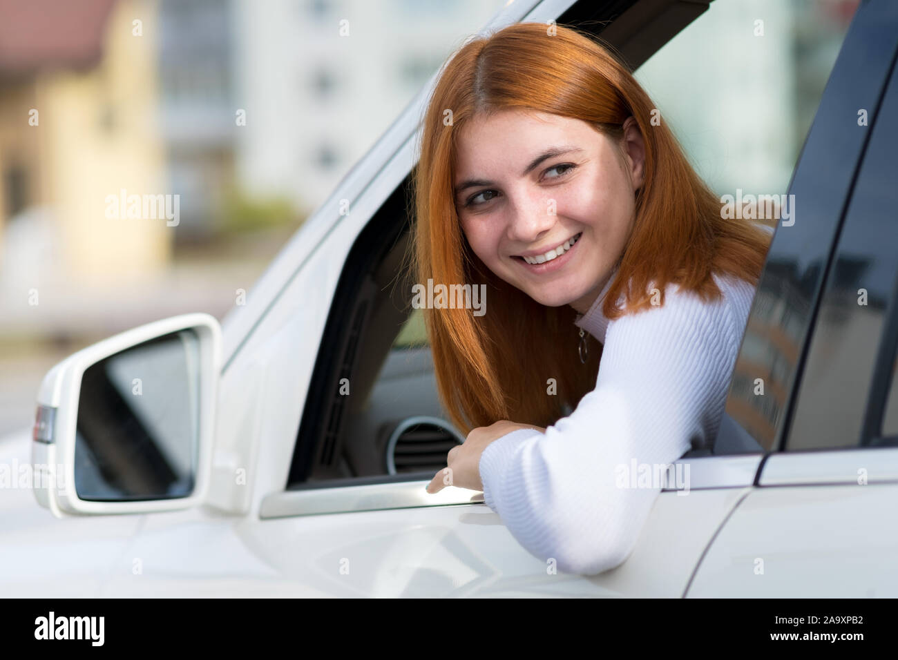 Young woman with red hair driving a car Stock Photo - Alamy