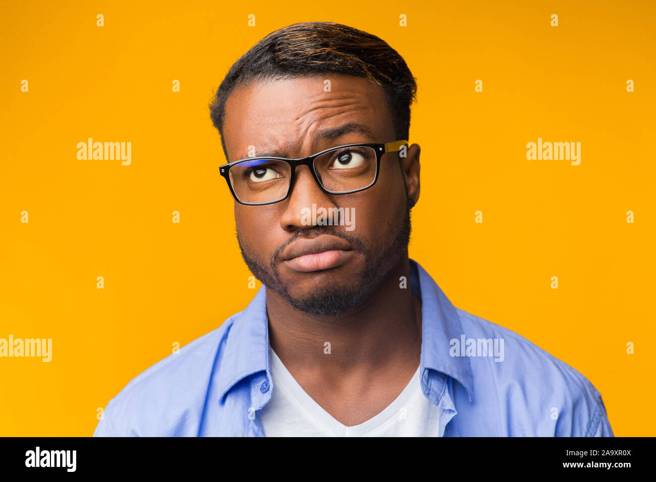 Puzzled African American Man Thinking About Something Standing, Orange ...