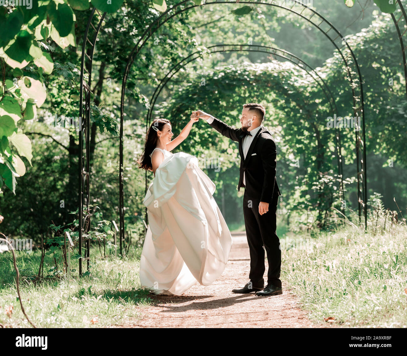 happy bride and groom dancing under the wedding arch Stock Photo - Alamy