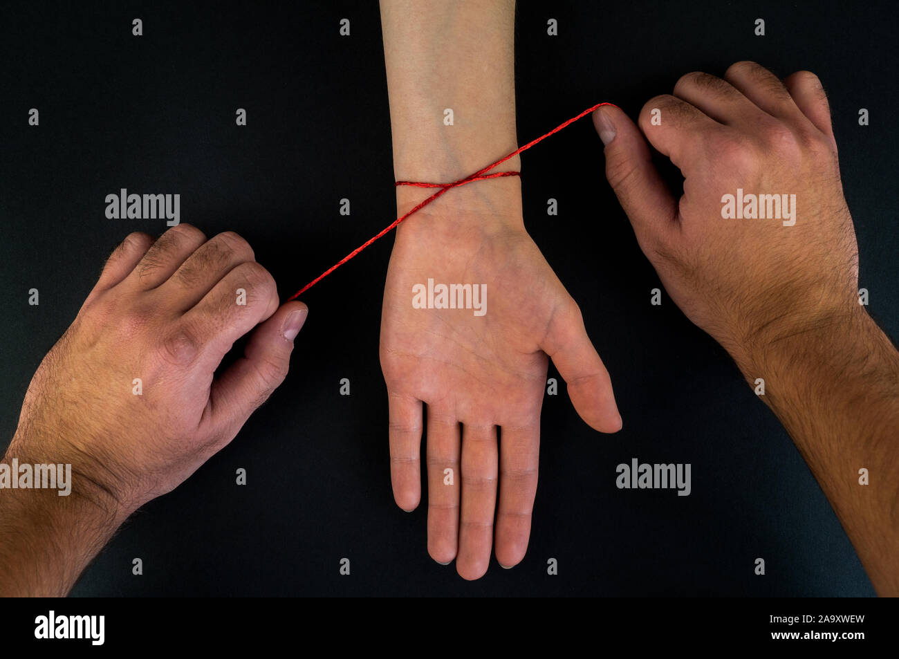 Red thread on a black background in the cart Stock Photo - Alamy