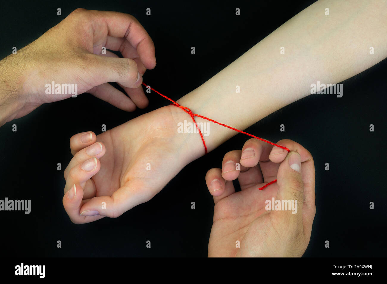 Red thread on a black background in the cart Stock Photo - Alamy