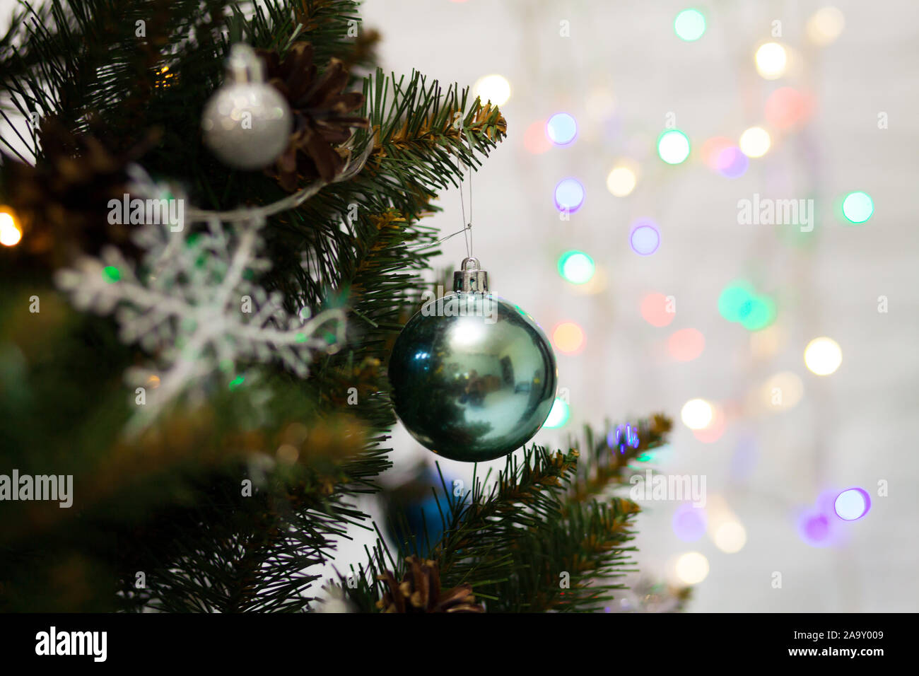 Beautiful green Christmas tree decorated with balls and garlands. Close ...