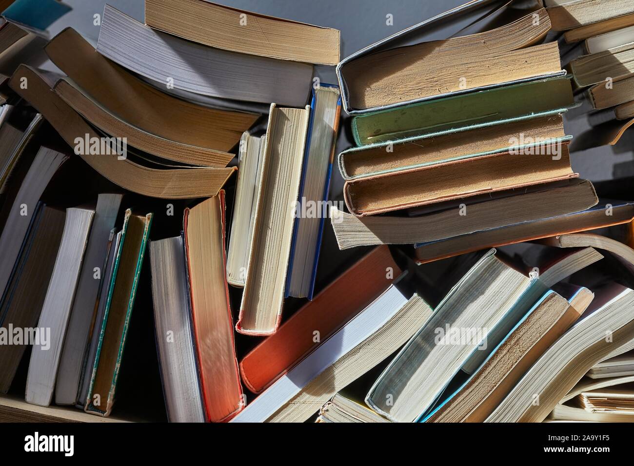 Wall of books piled up Stock Photo - Alamy