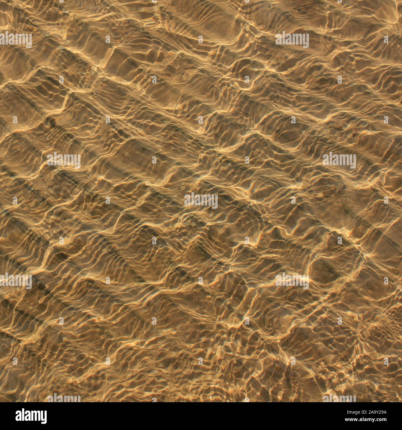 Reflections in the water over the sandy ground of Lake Vanern, Sweden ...
