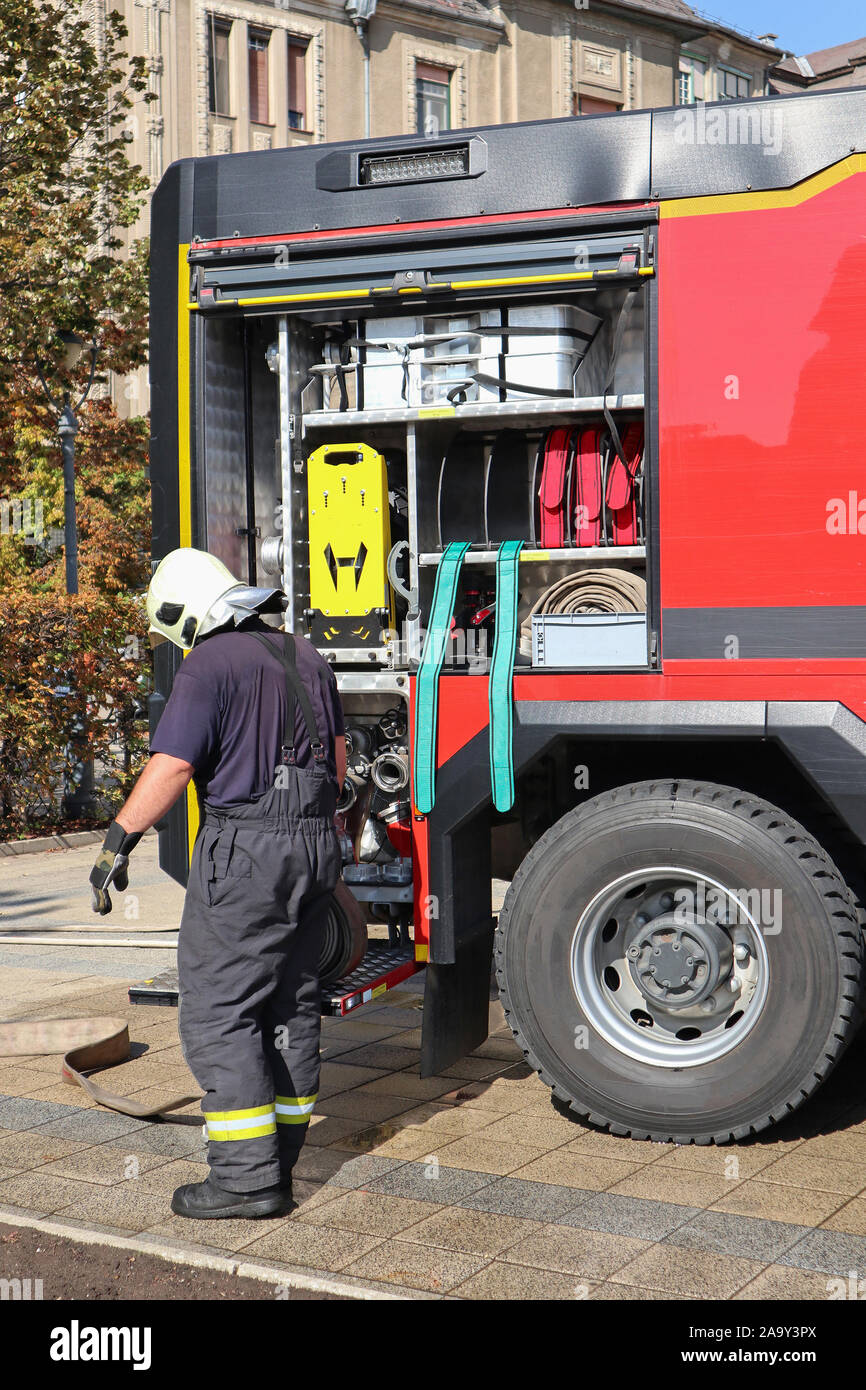 Firefighter next to the firefighter truck Stock Photo - Alamy