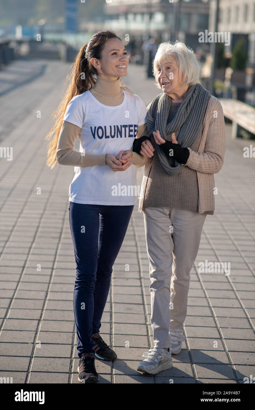 Homeless woman feeling grateful while walking and talking to volunteer ...