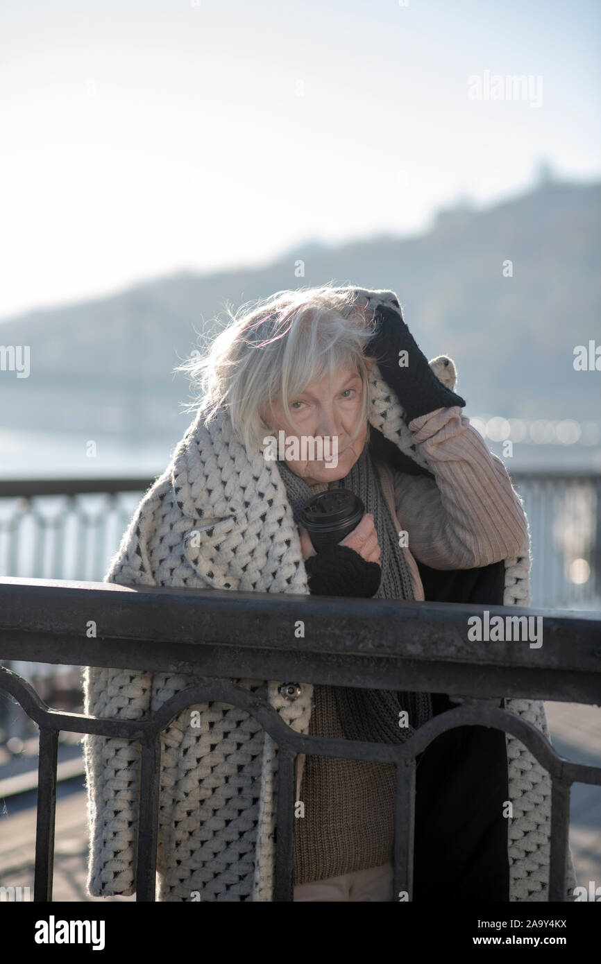 Poor homeless aged woman staying alone in the street Stock Photo - Alamy