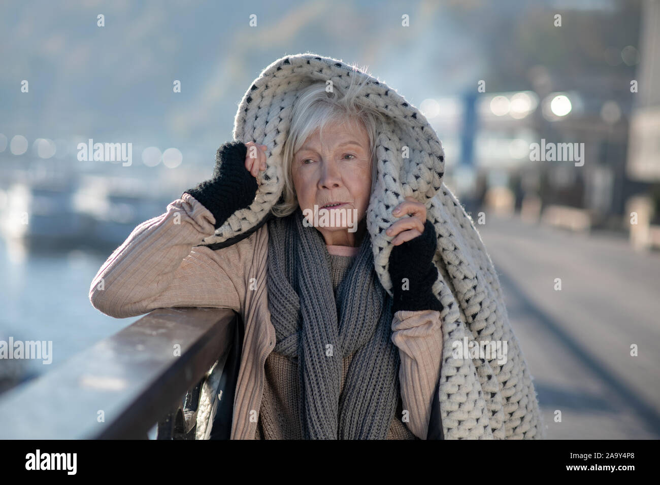Poor homeless woman feeling very cold thus putting coat on head Stock ...