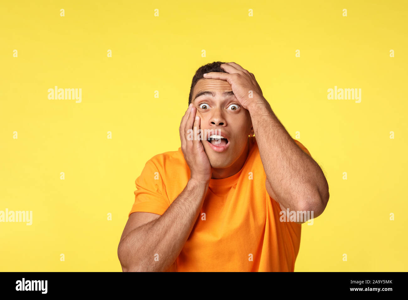 Scared, stunned and speechless frightened handsome man, grab head ...