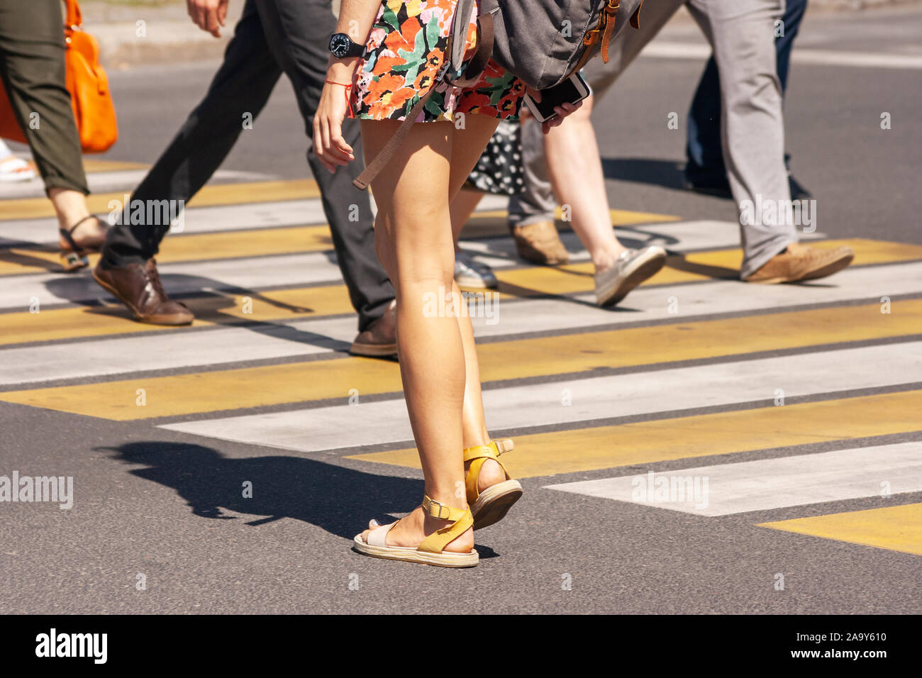 pedestrians crossing the road at a crosswalk in the city on summer day ...
