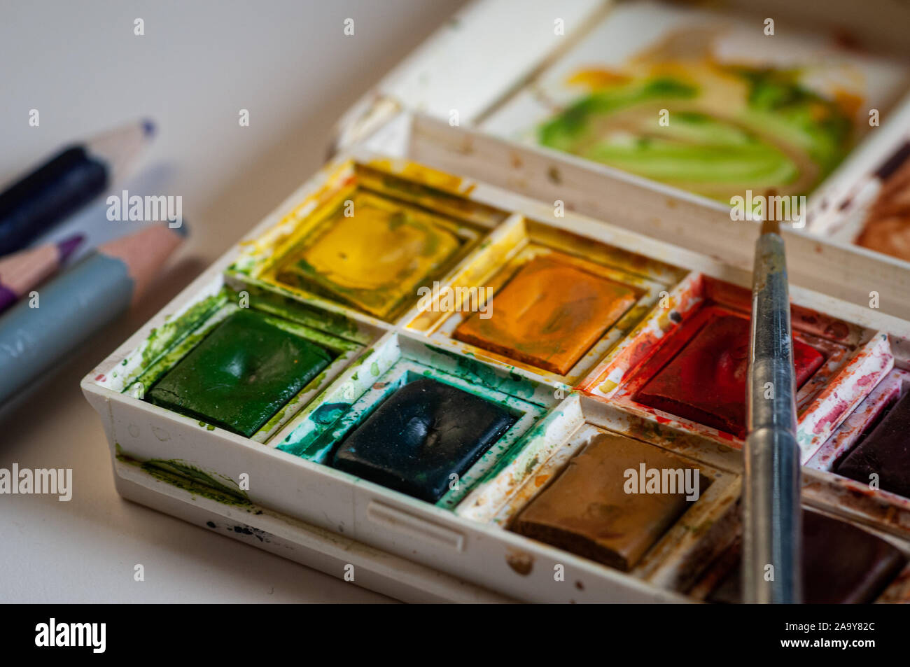 messy box of watercolour paints and brush , close up.with pencils Stock ...