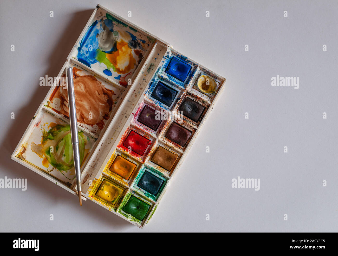 messy box of watercolour paints and brush on sheet of white paper Stock ...