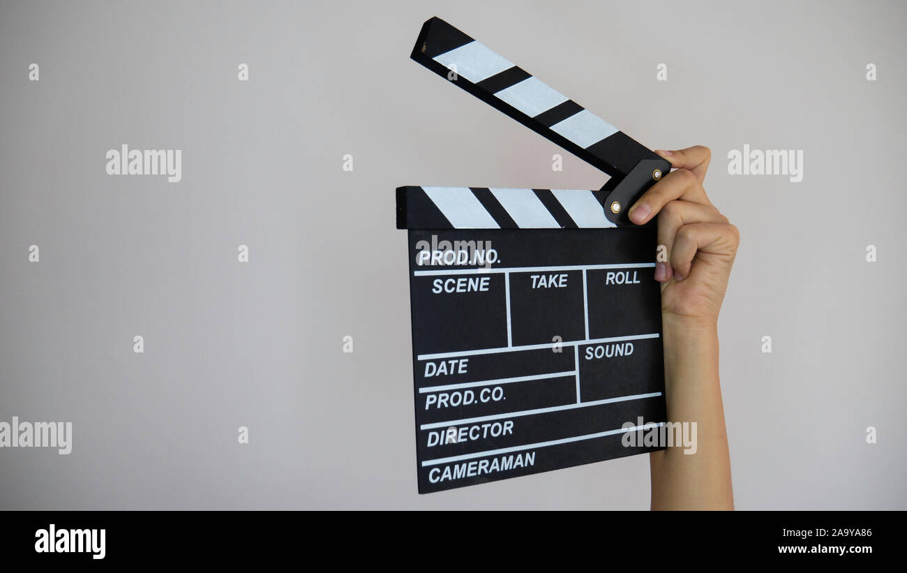 Close up female holding in hand classic director clear empty black film ...