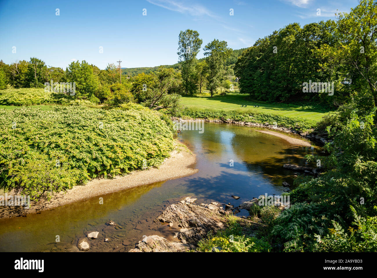 A colorful landcape reflected in the Little River in Stowe, Vermont ...